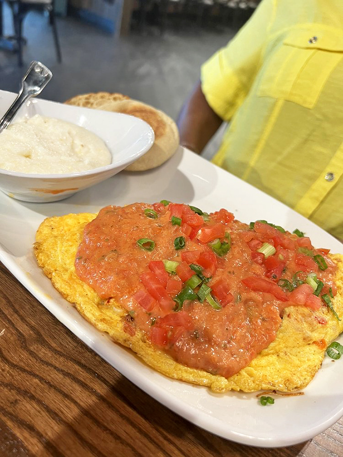 This isn't just breakfast, it's edible artwork—a vibrant omelet topped with fresh tomatoes and herbs that practically demands a moment of silence.