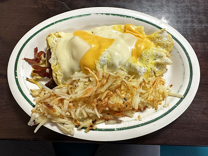Eggs wearing a melted cheese tuxedo next to hash browns dressed for success. This plate doesn't just feed you&mdash;it respects you.