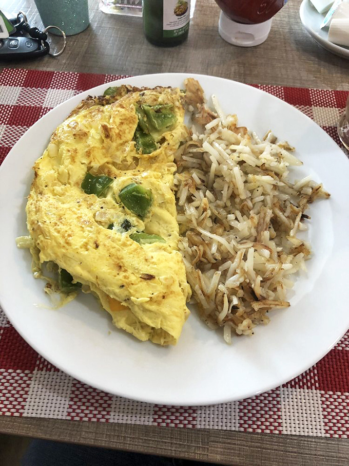 Green peppers peeking through golden eggs like hidden treasures, with hash browns standing by ready for their supporting role in your breakfast drama.