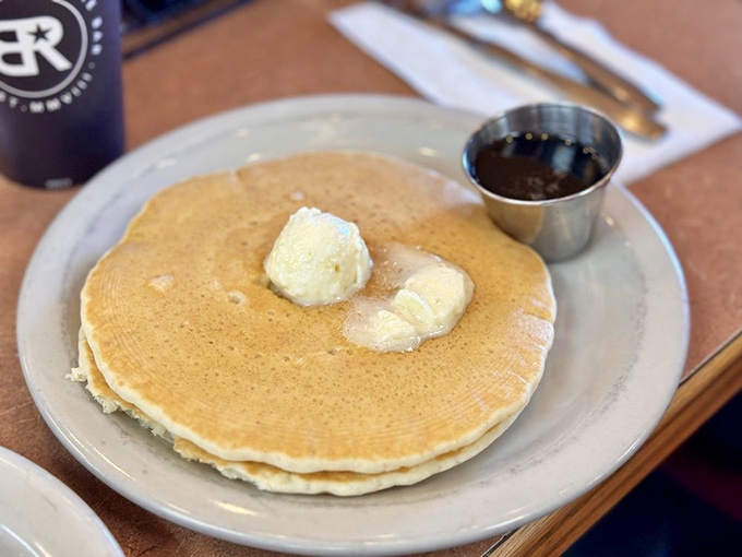 The pancake that launched a thousand return visits. Golden, fluffy, and waiting for its maple bath&mdash;breakfast nirvana on a humble plate.