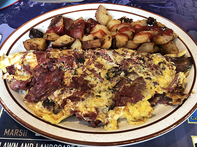 This isn't just any omelet&mdash;it's a meat-lover's dream where corned beef has found its eggy soulmate. Those home fries look like they're auditioning for a food magazine.