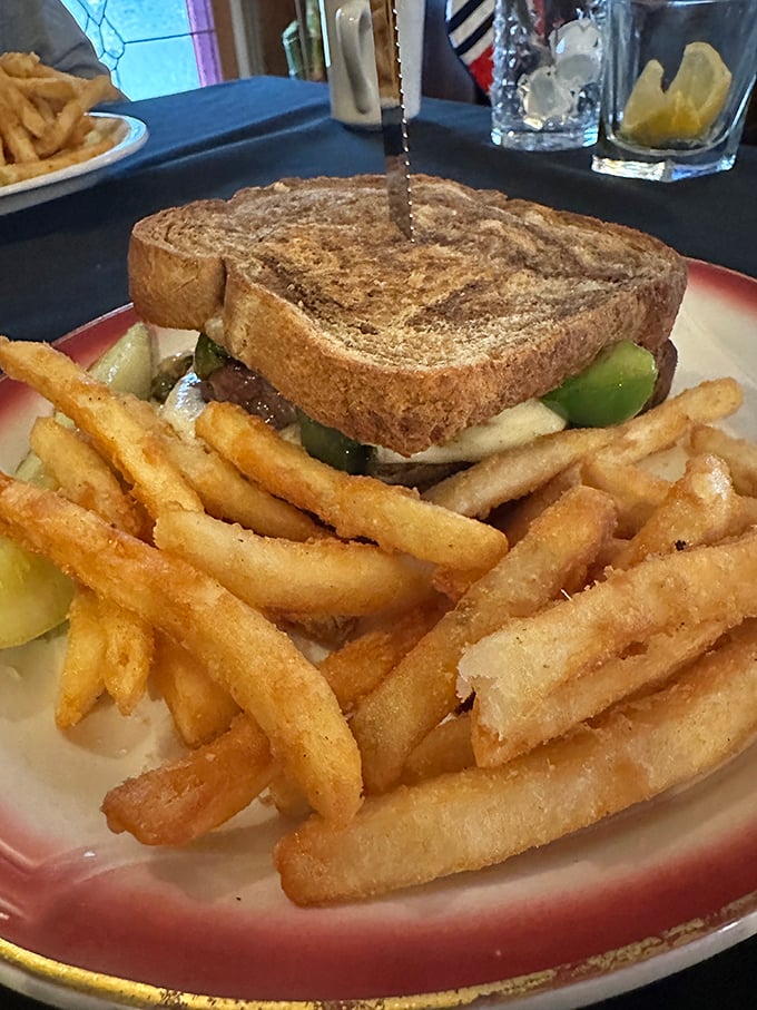 Not just a sandwich, but an architectural marvel of comfort food. This golden-grilled creation with crispy fries proves simple food done right is anything but basic.