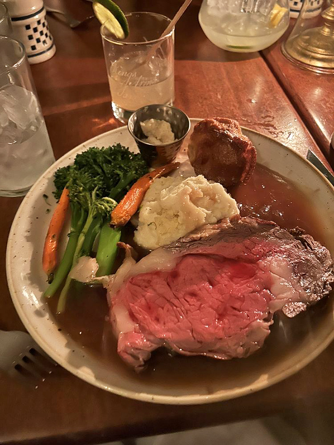 The prime rib glistens in candlelight, making a compelling case that perhaps our colonial ancestors knew a thing or two about the finer points of beef.