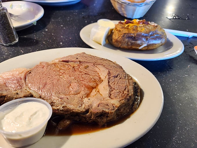 A study in contrasts: the primal satisfaction of perfectly cooked beef alongside a humble baked potato waiting for your personal touch.