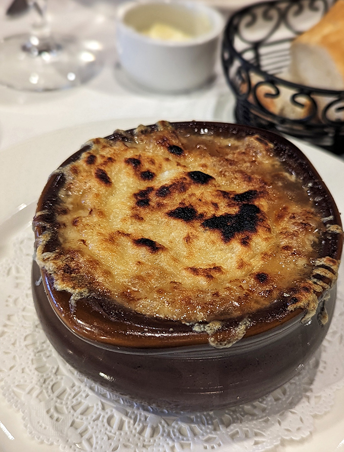 Another angle of the legendary French onion soup&mdash;where the broiled cheese forms a magnificent crust that gives way to the rich, savory broth beneath.