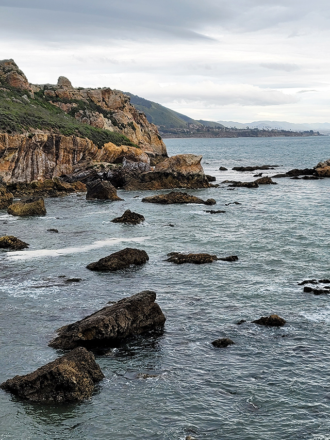 Rocky sentinels stand guard where land meets sea. They've been perfecting their poses for millions of years—talk about commitment to the bit.
