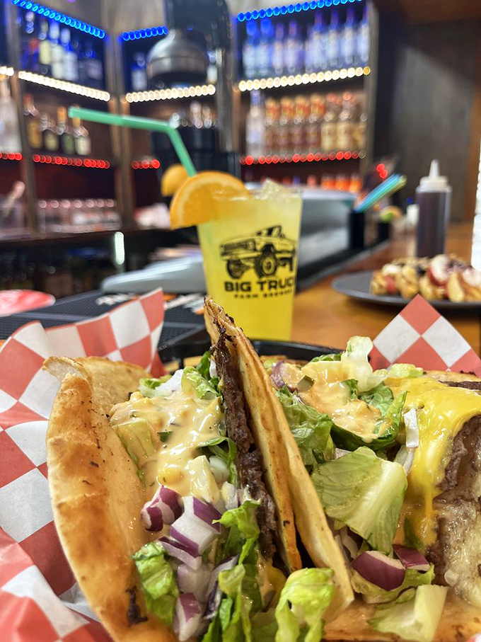 Tacos with attitude served on classic checkered paper. That yellow beverage isn't just a drink&mdash;it's sunshine in a glass waiting to brighten your day.