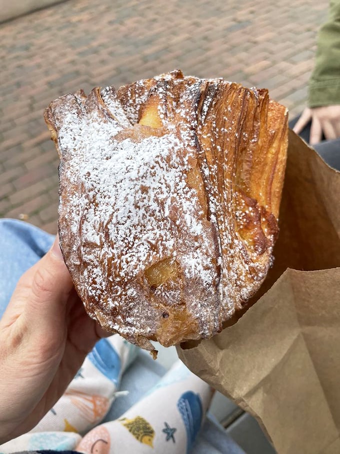 Powdered sugar snowfall on a buttery landscape&mdash;this almond croissant isn't just breakfast, it's an edible work of art.