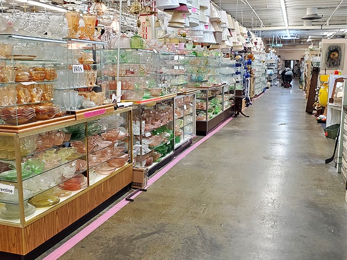 Depression glass glimmers under the fluorescent lights, each delicate piece whispering stories of elegant dinner parties from another era.