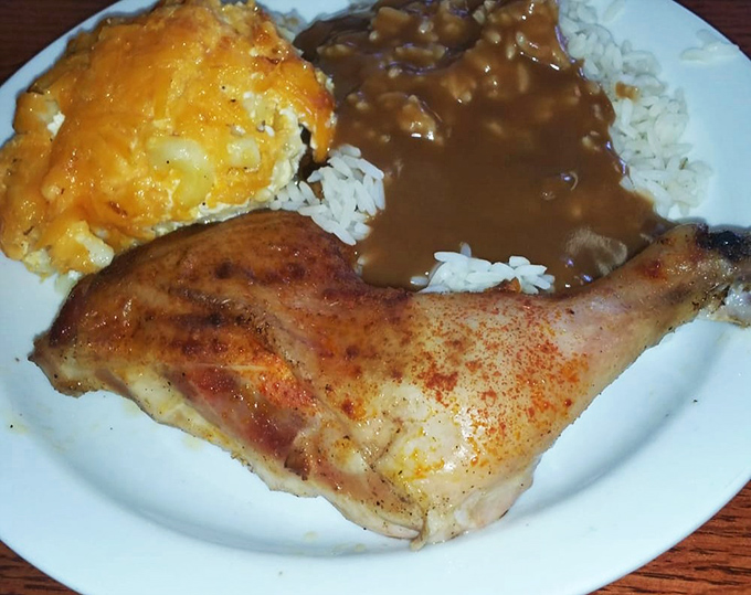 Baked Chicken: Perfectly seasoned chicken alongside mac and cheese and rice with gravy &ndash; Southern comfort on a single plate.