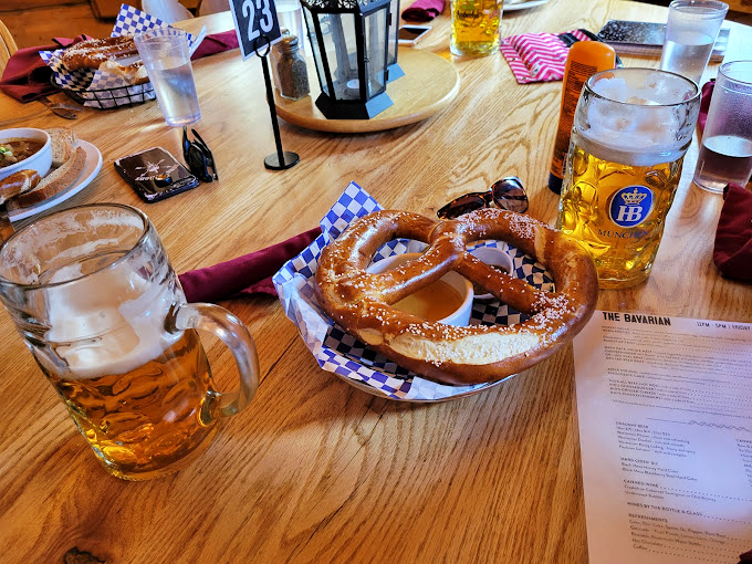 The pretzel arrives like royalty on its blue-checkered throne, commanding respect and mustard in equal measure.