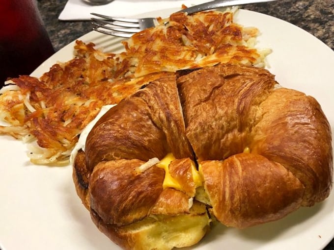 The croissant breakfast sandwich—where buttery pastry meets morning protein—sharing the spotlight with those famous hash browns that deserve their own fan club.