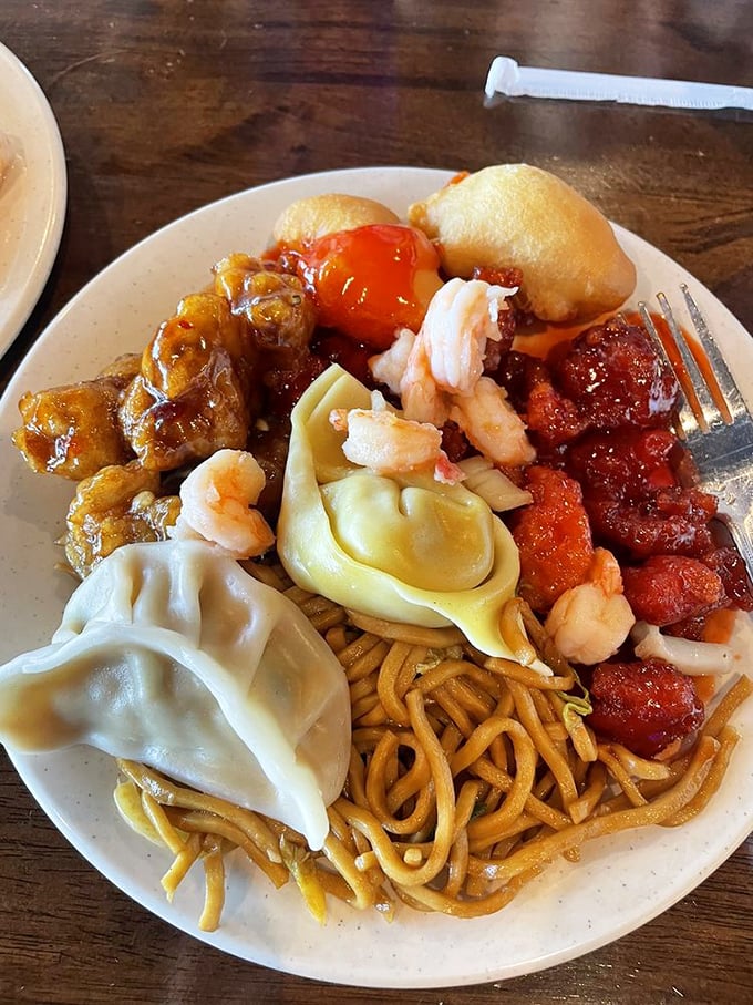A masterclass in buffet plate architecture&mdash;dumplings, noodles, sweet and sour pork, and shrimp creating a skyline of flavors that would make any food photographer proud.