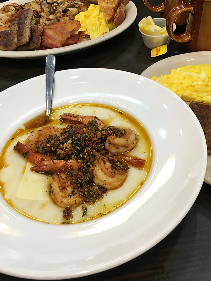 The holy trinity of breakfast perfection: seasoned shrimp, creamy grits, and a sauce so good you'll be tempted to lick the plate when no one's looking.