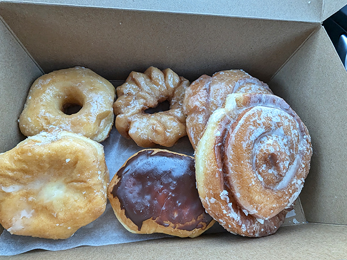 The box opens to reveal a treasure chest of golden-fried perfection. Six different paths to happiness, each one glazed, filled, or frosted to perfection.