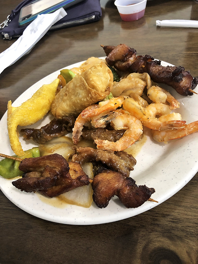 A plate that tells the story of buffet strategy&mdash;a little of this, a bit of that, and somehow those skewers always find their way into the mix.