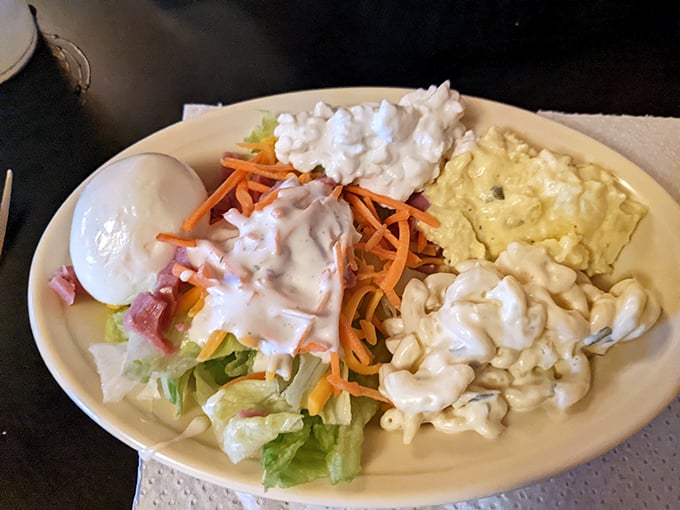 Side salad or work of art? Crisp lettuce, creamy potato salad, and macaroni salad create a symphony of textures that perfectly complement the fried main attractions.