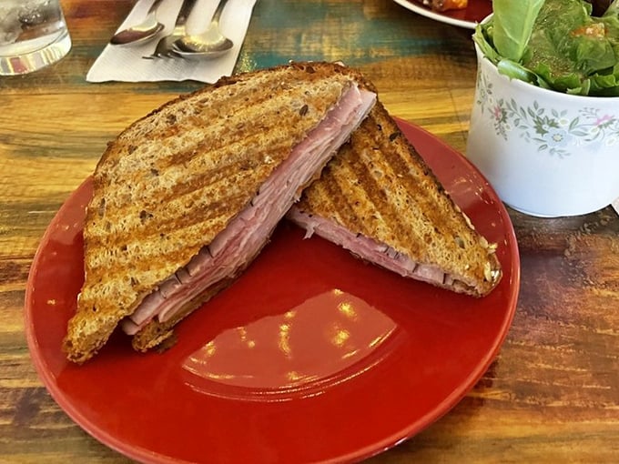 A grilled sandwich that proves OoeyGooey isn't just a one-trick pony&mdash;the perfect marriage of crispy exterior and melty interior on a striking red plate.