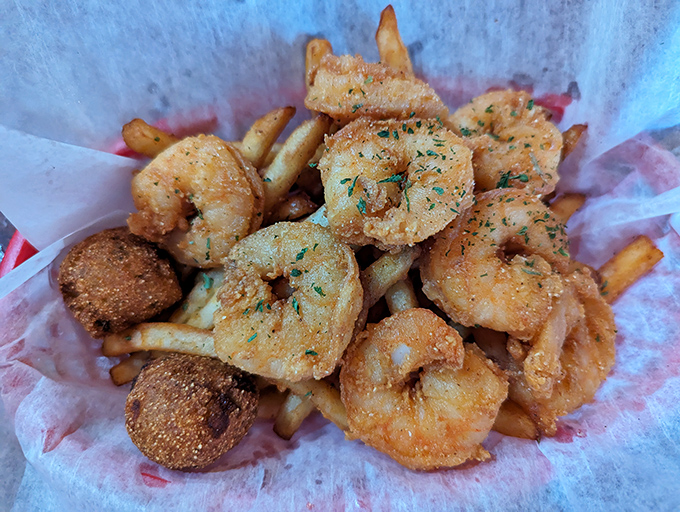 Golden-fried shrimp and hush puppies nestled on a bed of fries &ndash; proof that sometimes the simplest pleasures are the most satisfying.
