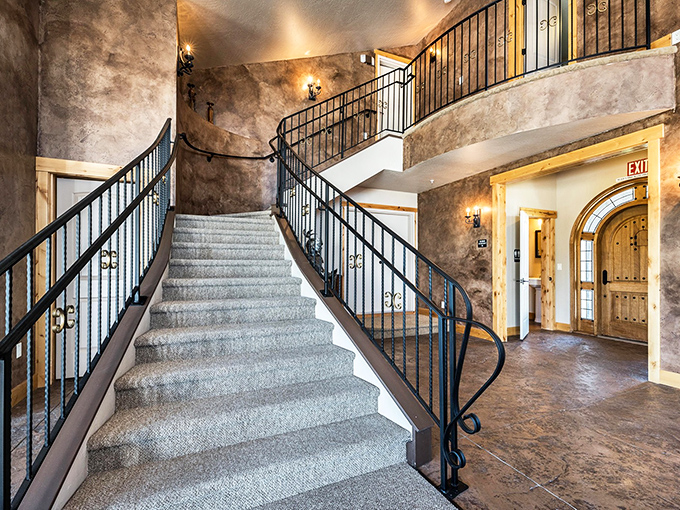 The grand staircase sweeps upward with all the drama of a royal entrance, complete with a knight in shining armor standing guard. Trumpeters not included.