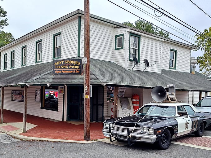 A vintage police cruiser stands guard outside St. Georges Country Store, where history and homestyle cooking create the perfect small-town experience.