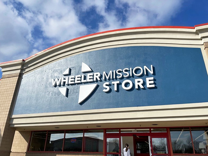 The curved blue facade of Wheeler Mission Store stands out like a retail oasis, offering both incredible deals and the warm fuzzy feeling of shopping for a cause.