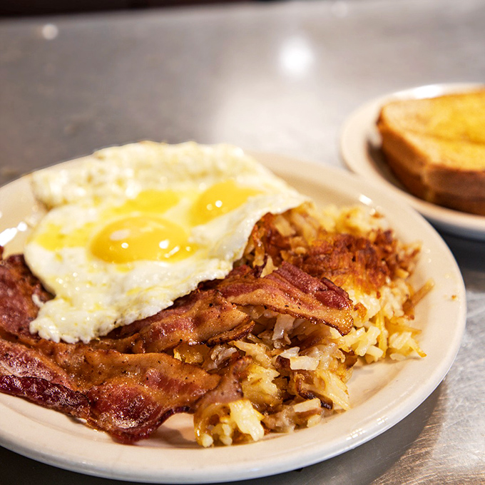 The breakfast trinity: perfectly crisp hash browns, bacon with the ideal crisp-to-chew ratio, and eggs that remember exactly how you like them. 