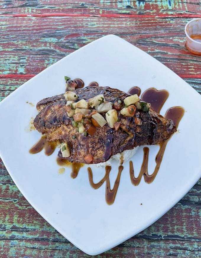 This blackened fish with pineapple salsa isn't just dinner&mdash;it's edible artwork. The sauce swirls are like the chef's signature on a masterpiece.