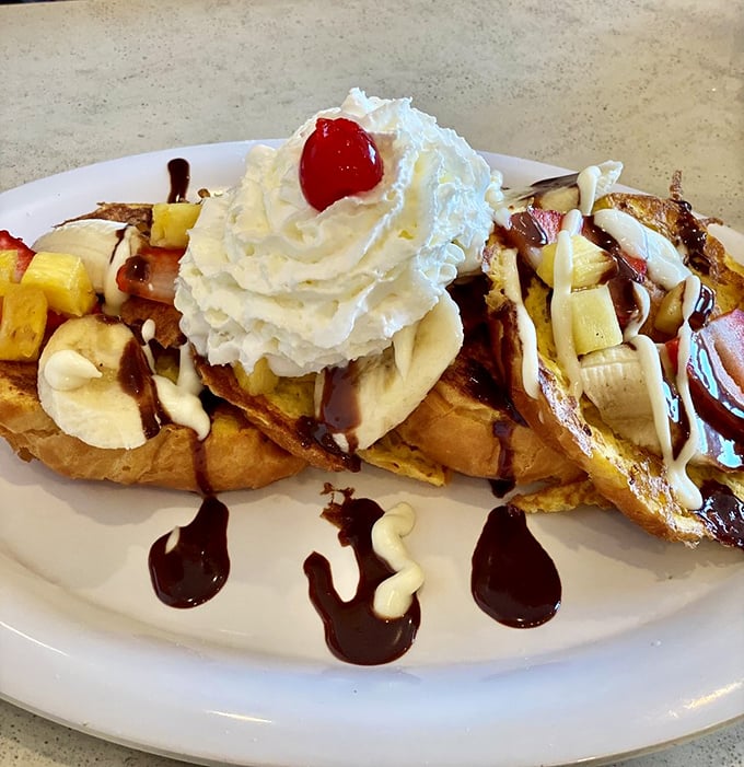 Bananas, whipped cream, and chocolate drizzle transform ordinary French toast into a breakfast that feels delightfully illegal before noon.