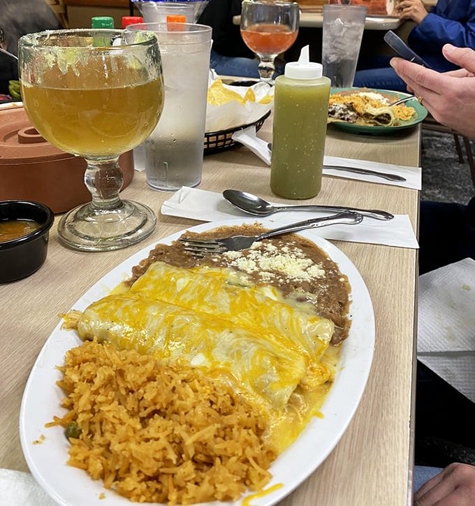 A margarita stands guard beside enchiladas that glisten with cheese. This plate isn't just a meal&mdash;it's an event.