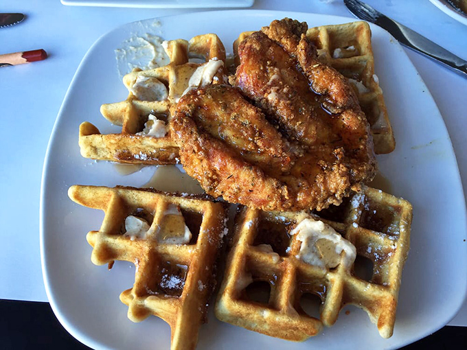 A waffle supporting crispy chicken like a stage holds a headlining act, with butter melting into each square like it's found its forever home.