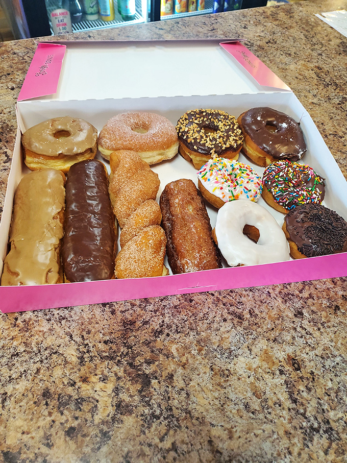 A pink box of joy containing more happiness than most people experience in an entire week. Variety is the spice of donut life.