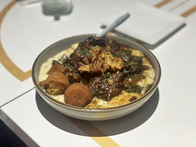 Braised oxtails nestled on creamy grits&mdash;the kind of dish that makes you want to cancel your afternoon plans and surrender to a food coma.
