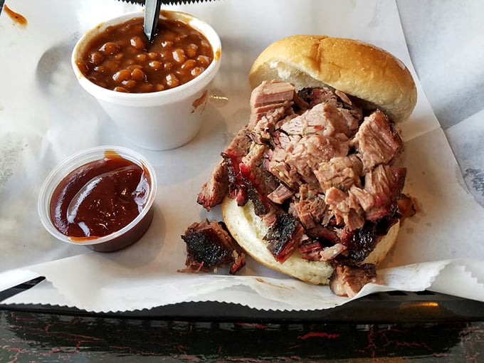 This isn't just a sandwich; it's an architectural marvel of smoked brisket that requires both hands, several napkins, and absolutely no distractions. 