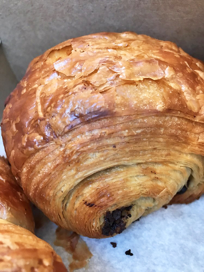 The chocolate croissant's golden exterior holds within it the secret to happiness: ribbons of flaky pastry embracing premium chocolate that melts just so.