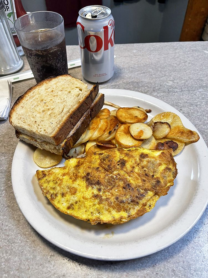 This omelet and home fries combo isn't just breakfast&mdash;it's a commitment. Toast stands by, ready to soak up any egg goodness that tries to escape.