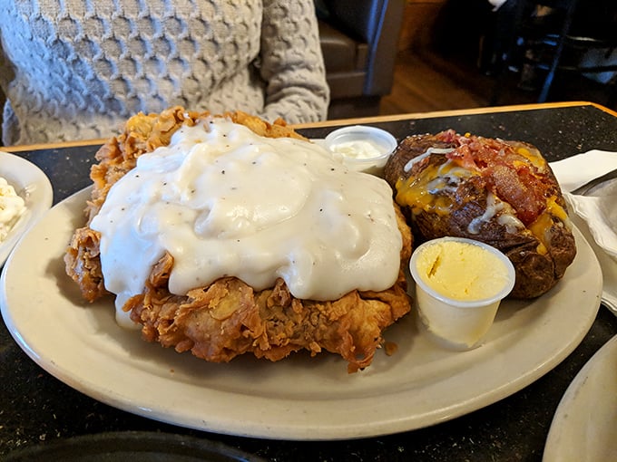Country fried steak smothered in cream gravy with a loaded baked potato&mdash;because sometimes comfort food is the only language that truly speaks to the soul.