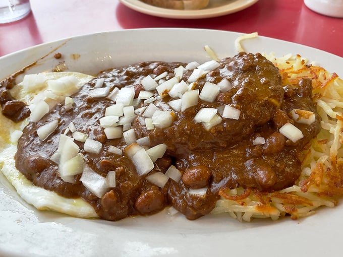 The legendary St. Louis "Slinger" in its natural habitat &ndash; where hash browns bravely support a mountain of chili in a delicious architectural marvel.