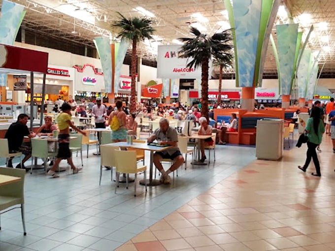 The food court jungle: palm trees indoors, a symphony of food smells, and the universal language of "I need sustenance before I buy another thing."