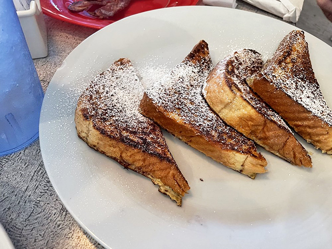 French toast dusted with powdered sugar waits for your fork like golden slices of morning heaven&mdash;proof that simple pleasures remain the most satisfying.