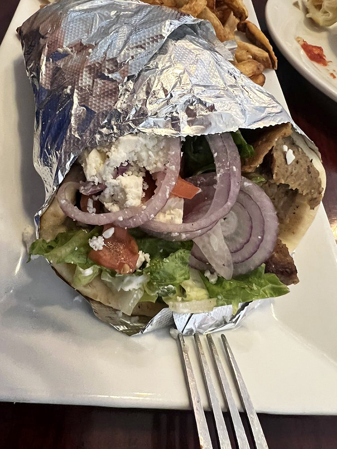 Peek inside this foil-wrapped treasure and discover why locals make pilgrimages here &ndash; fresh veggies, feta, and meat in perfect harmony.