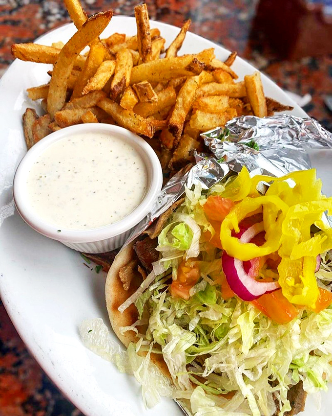 The perfect marriage: crispy golden fries, a foil-wrapped gyro, and tzatziki sauce that deserves its own fan club.