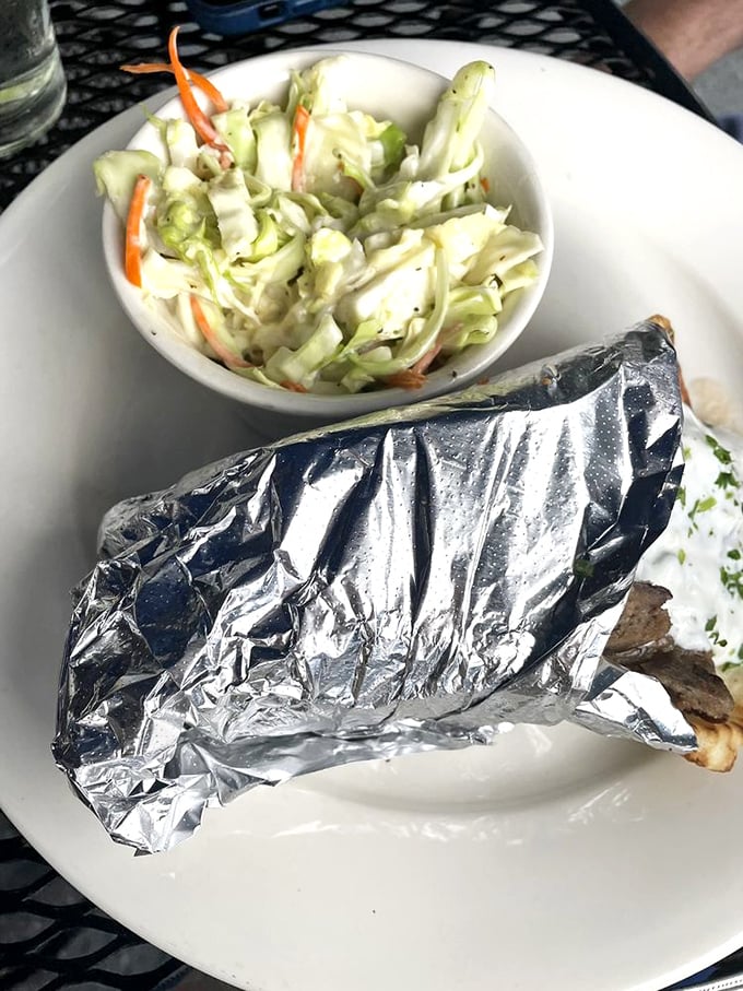 Wrapped in foil like a precious gift, this gyro comes with a side of coleslaw that's not just an afterthought but a worthy companion.