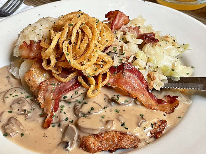 J&auml;gerschnitzel swimming in mushroom sauce with crispy bacon and fried onions&mdash;a dish so good it deserves its own national holiday.