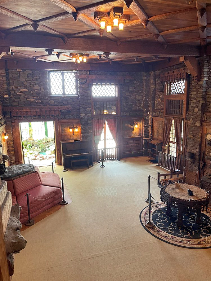 Sunlight streams through diamond-paned windows, illuminating a living room where medieval aesthetics meet early 20th-century comfort with surprising harmony.