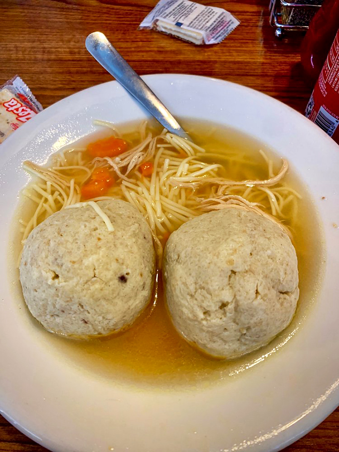 Double trouble! Two perfectly formed matzo balls nestled in broth so clear you could read your horoscope through it.