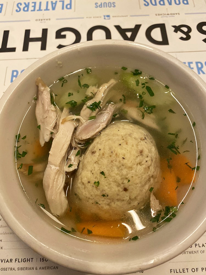 Another angle of matzo ball perfection &ndash; notice how the broth gleams with a clarity that only comes from slow-simmered, patient cooking.