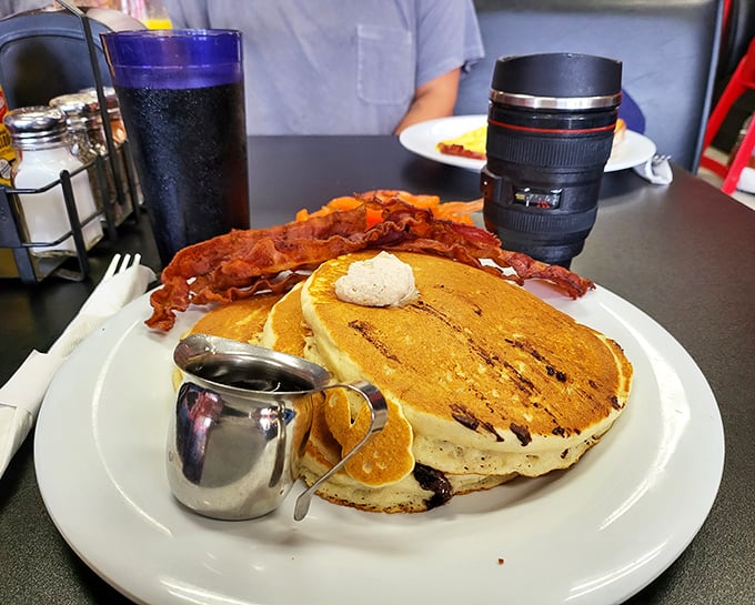Pancakes so perfect they deserve their own ZIP code. That crispy bacon looks like it's standing guard to make sure nobody steals your breakfast joy.