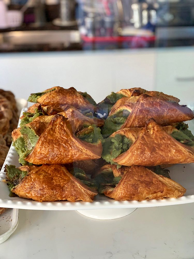 The pistachio croissants flaunt their vibrant green filling like peacocks showing off, daring you not to order at least two.
