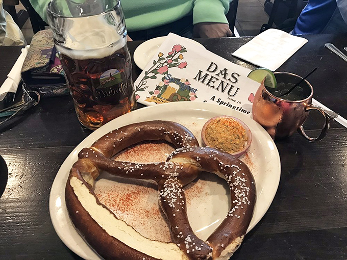 The holy trinity: a magnificent pretzel, mysterious mustard, and what appears to be a beer in the background. Some might call this heaven; Germans call it Tuesday.